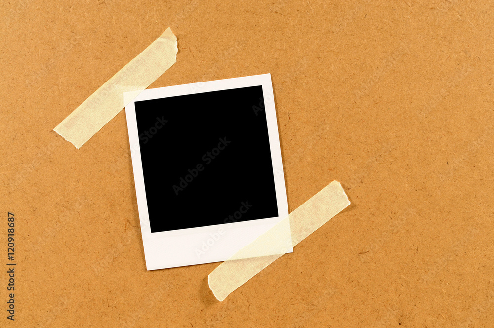 One single polaroid style photo print frame taped to a cork notice or ...