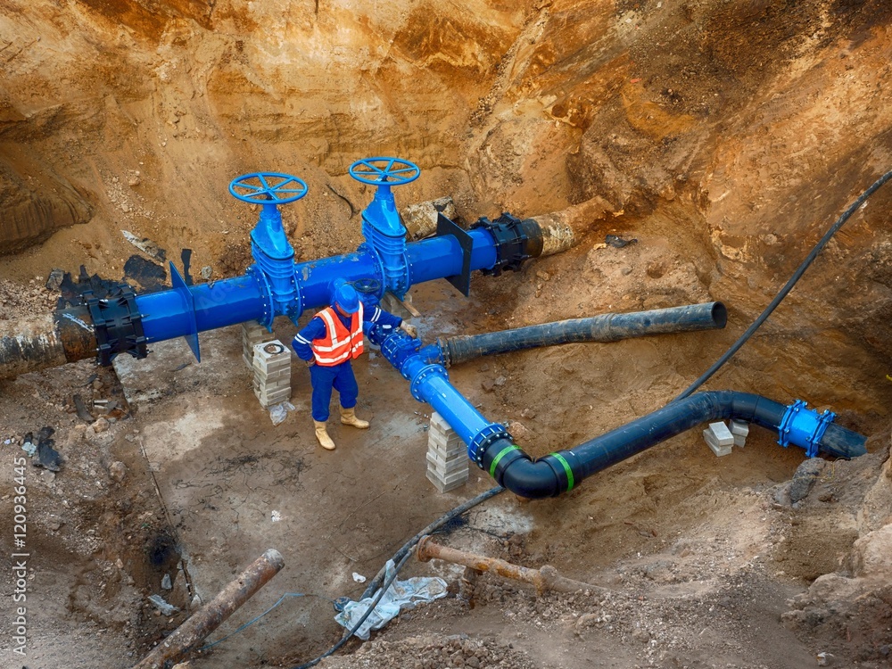 Worker underground at gate valve on drink water system, waga multi ...
