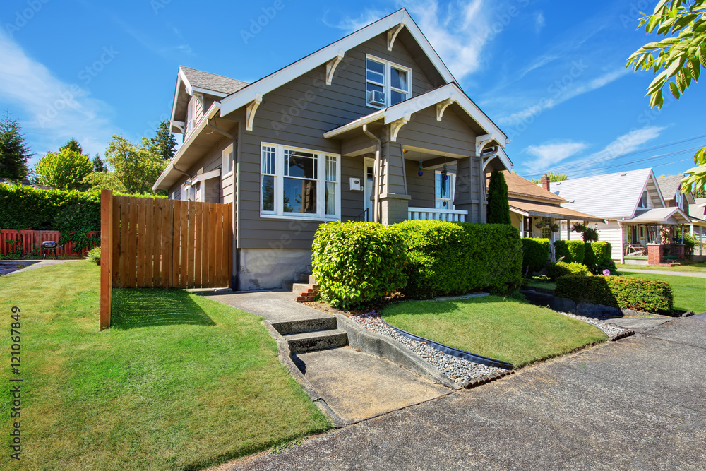 Classic American house exterior with siding trim and well kept garden ...