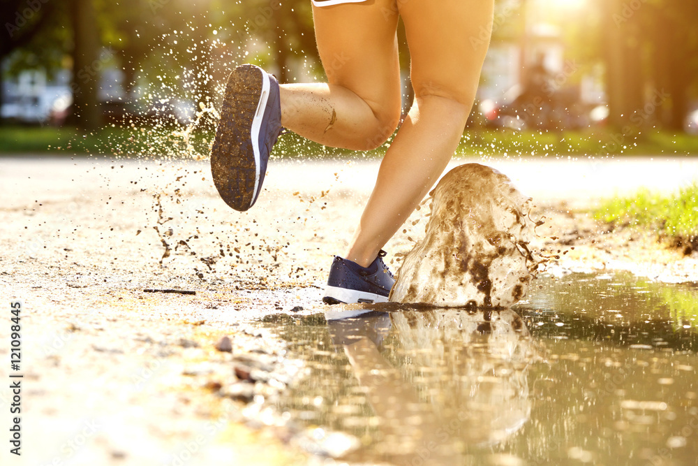 Splash in mud puddle by runner Stock Photo | Adobe Stock