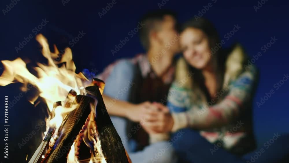 Romantic couple talking softly in the burning fire. Sharpness on the ...