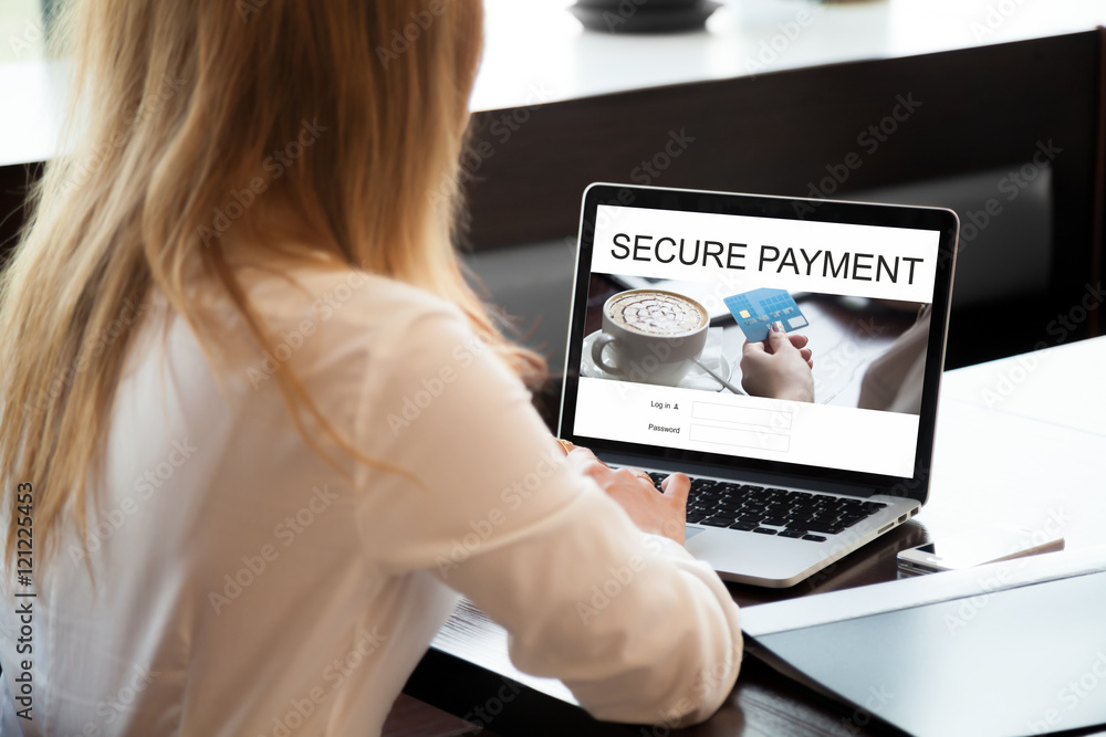 Young woman working on laptop computer, using secure payment software ...