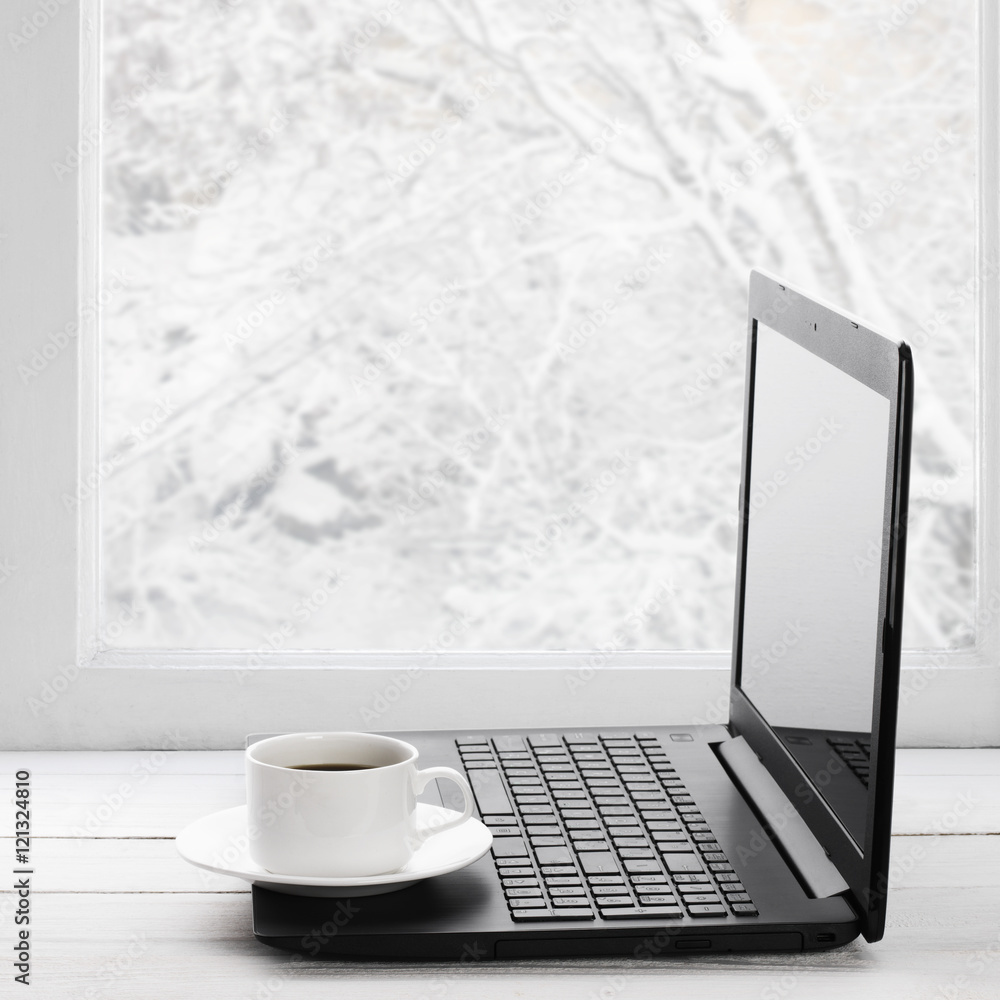Laptop and coffee on winter window Stock-Foto | Adobe Stock