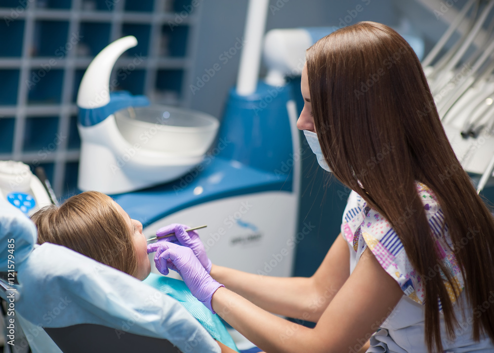 Dentist curing a child patient in the dental office in a pleasant ...