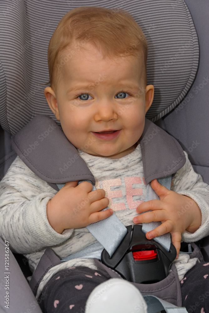 Kleinkind sitzt angeschnallt im Autositz Stock-Foto | Adobe Stock