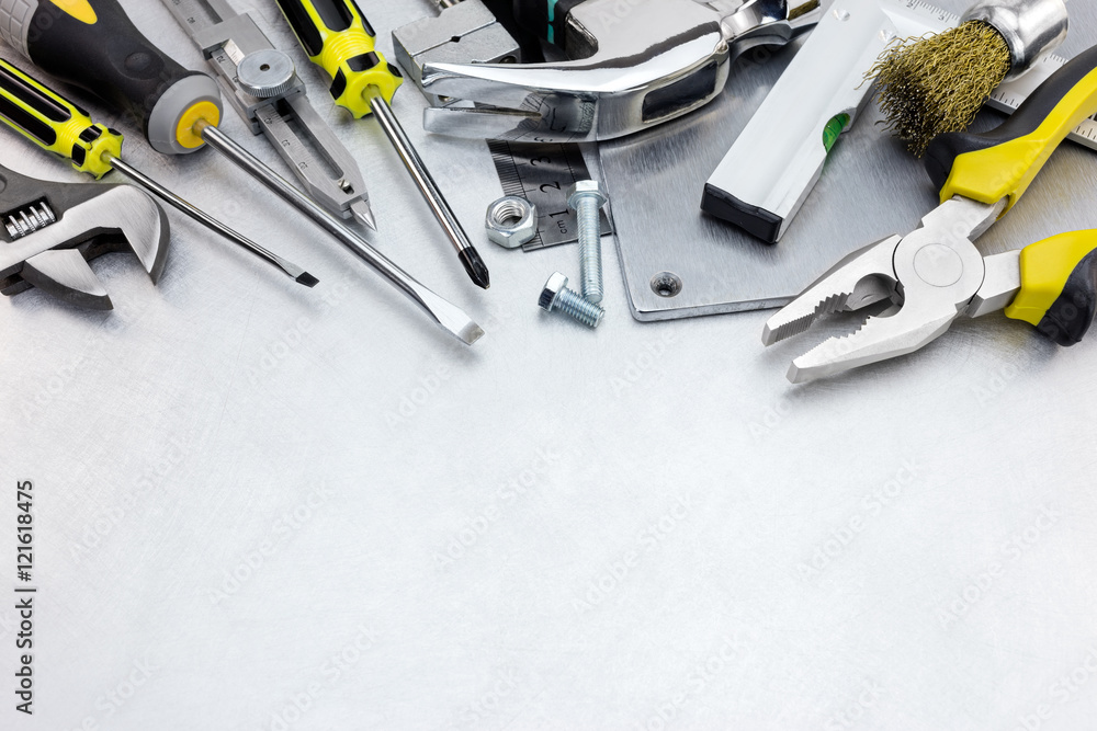 scratched metal background with yellow tool set and instruments for ...