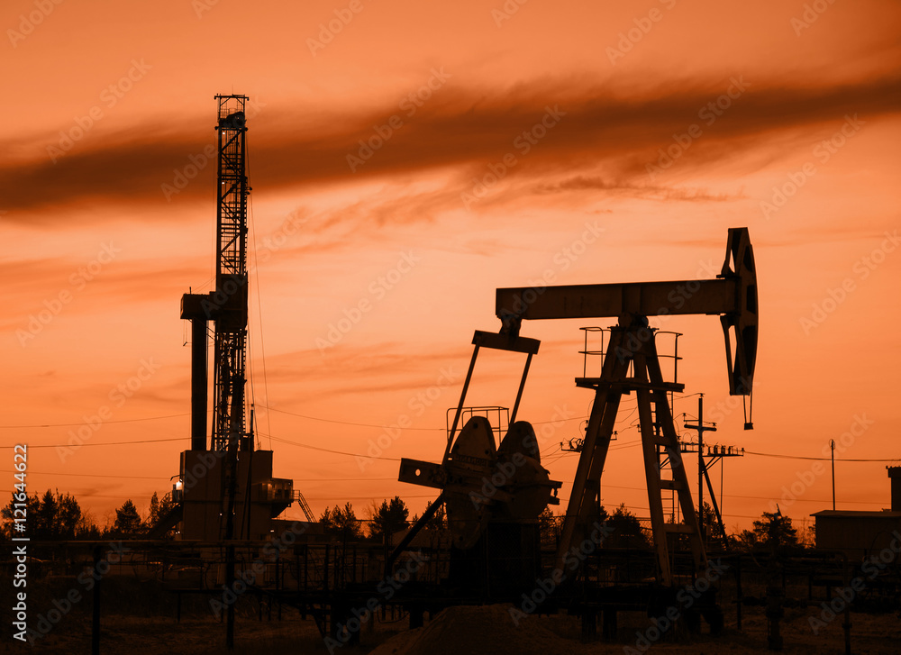 Oil rig and derrick silhouette during sunset in the oilfield. Oil and ...