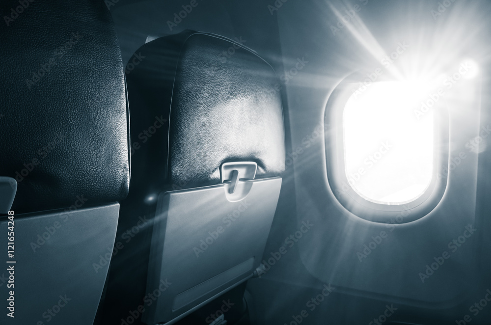 Jet chairs with folding tables, glowing porthole Stock Photo | Adobe Stock