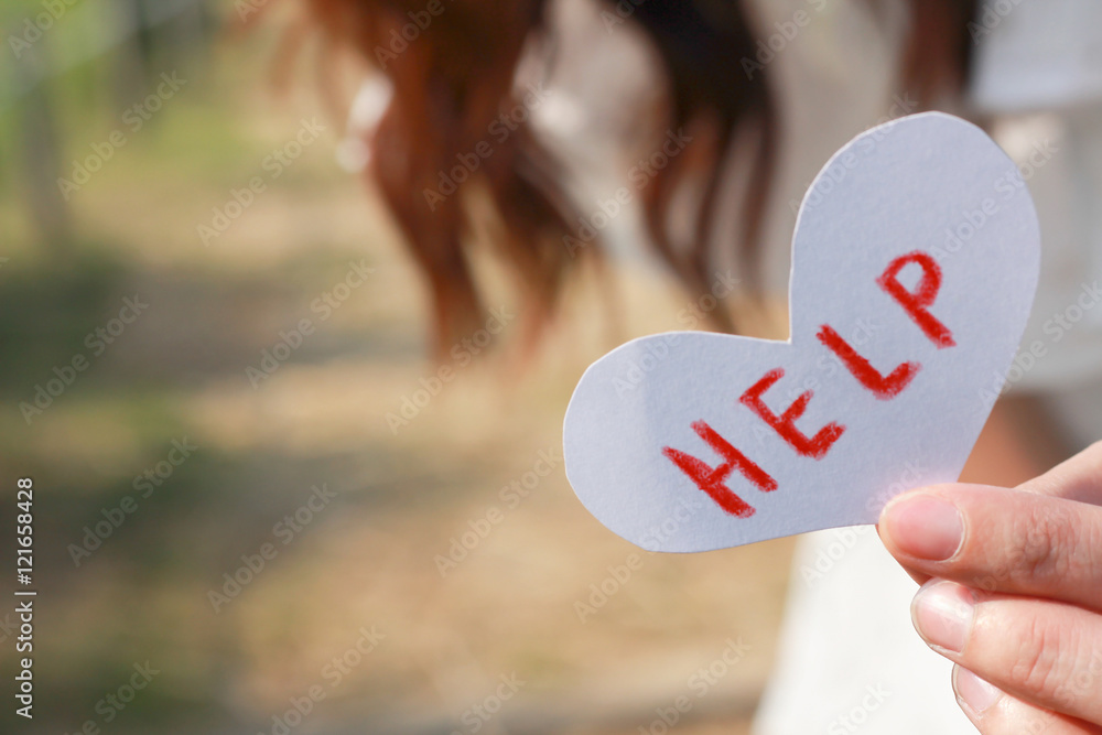 Foto Stock Hand holding the paper writing the word help | Adobe Stock
