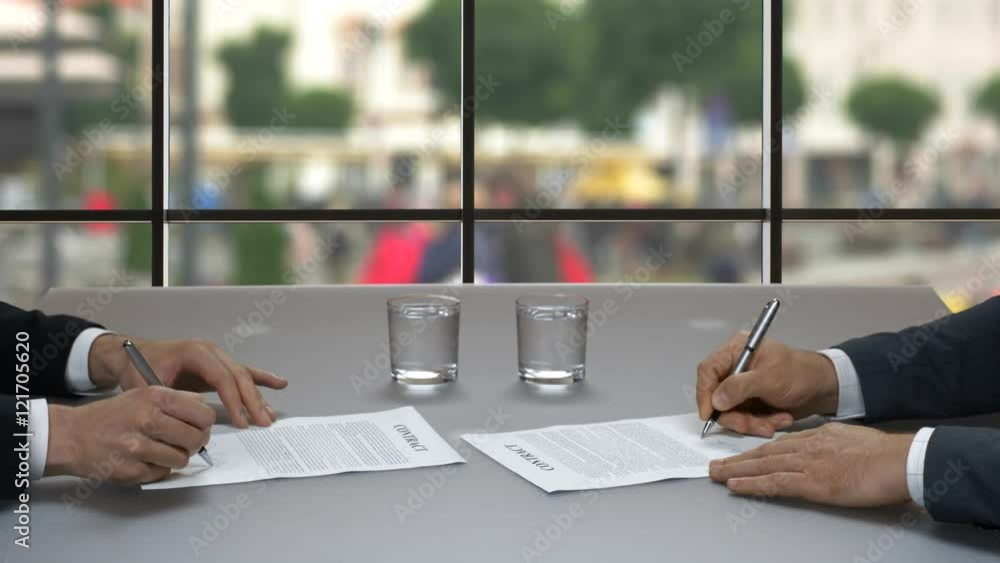 Two businessmen sign documents. Handshake on street background ...