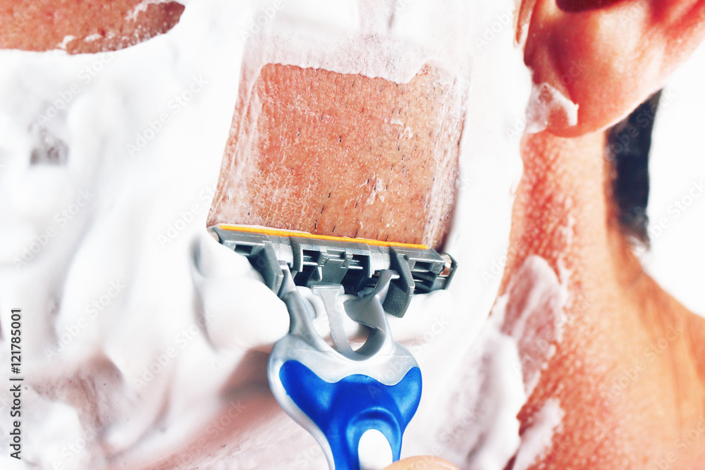 Hand man with a razor shaving his face close up, gently toned Stock ...