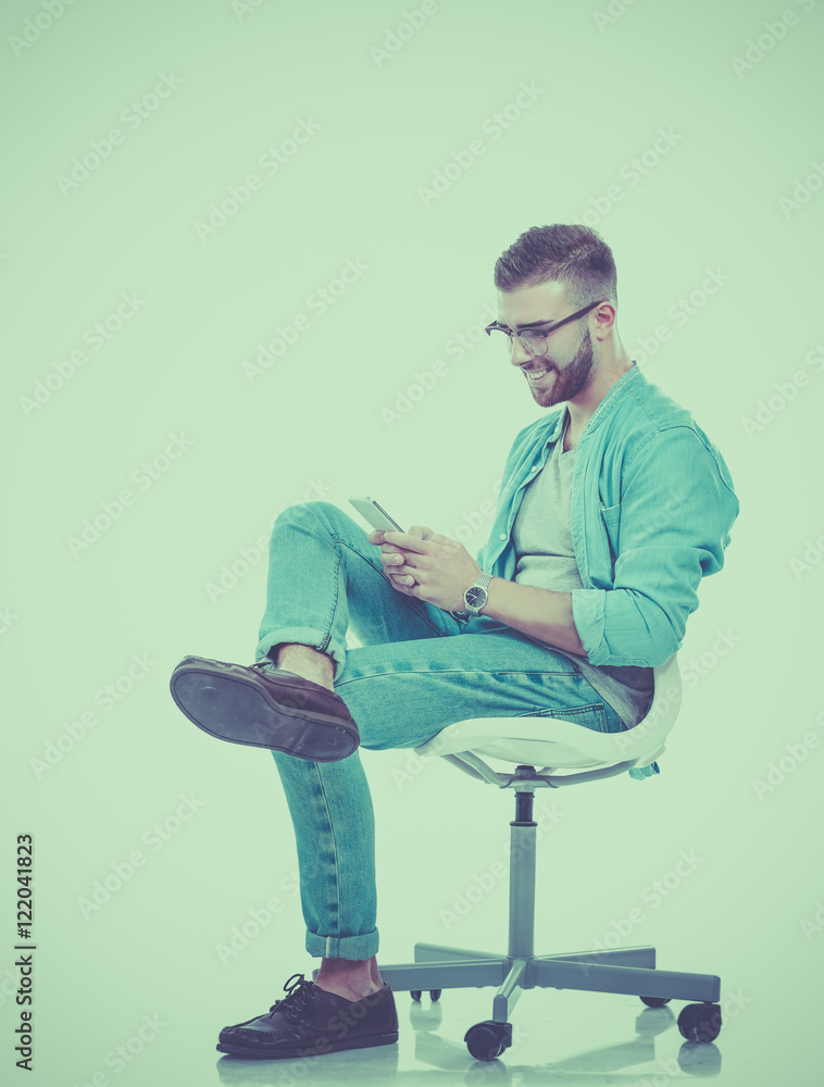 Young man sitting on chair and using mobile phone Stock Photo | Adobe Stock