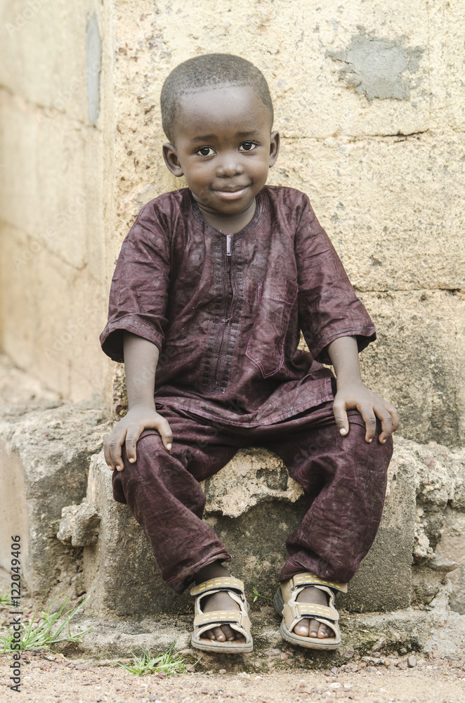 Handsome Little African Boy Sitting Outdoors whit a gentle smile on his ...
