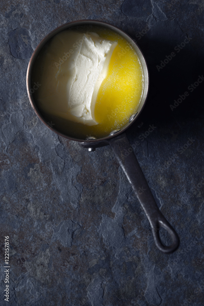 Melted butter in the stewpan on the stone background vertical Stock ...