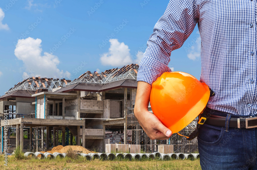 resident engineer holding yellow safety helmet at new home building ...