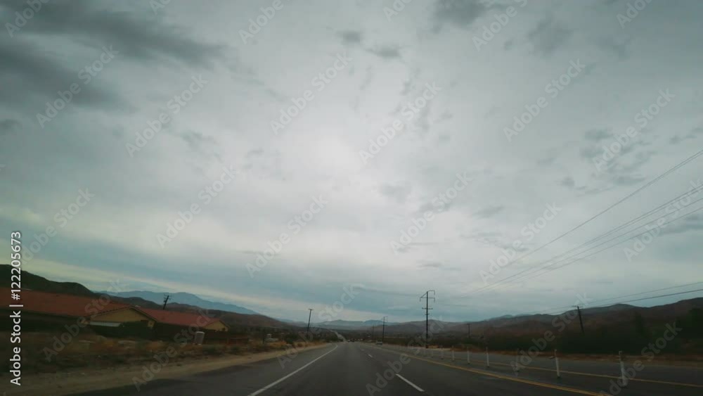 A rear view perspective looking back at highway from a moving car ...