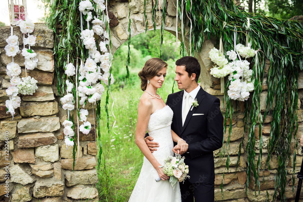 Wedding couple cuddling at the outside wedding ceremony on the nature ...