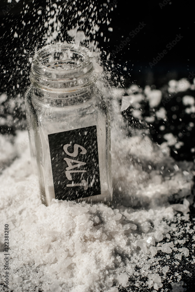sprinkled salt shakers of white salt on the black background Stock ...