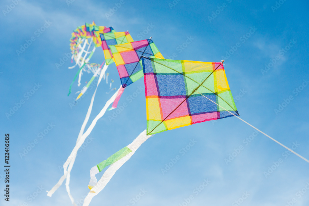 Colorful long line kites flying in blue sky Stock Photo | Adobe Stock