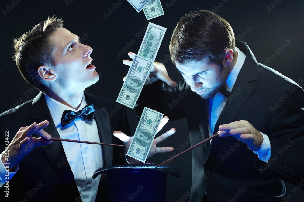 Two magicians making money with their wands in top hat Stock Photo ...