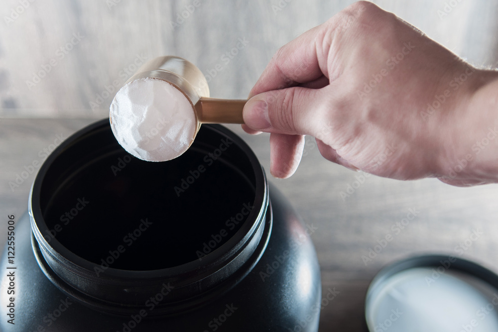 Hand holding doser and pouring food supplement in supplement pot Stock ...