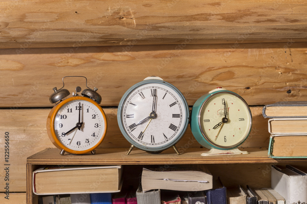 Old alarm clock on a shelf with books Stock Photo | Adobe Stock