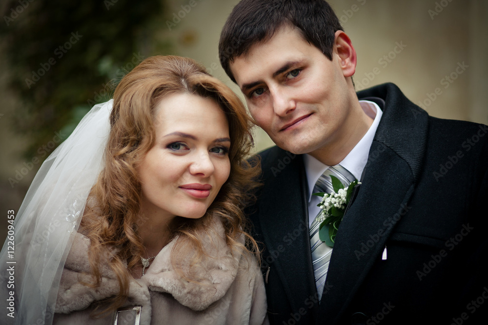 Classy groom and his gorgeous bride pose outside in winter coats Stock ...