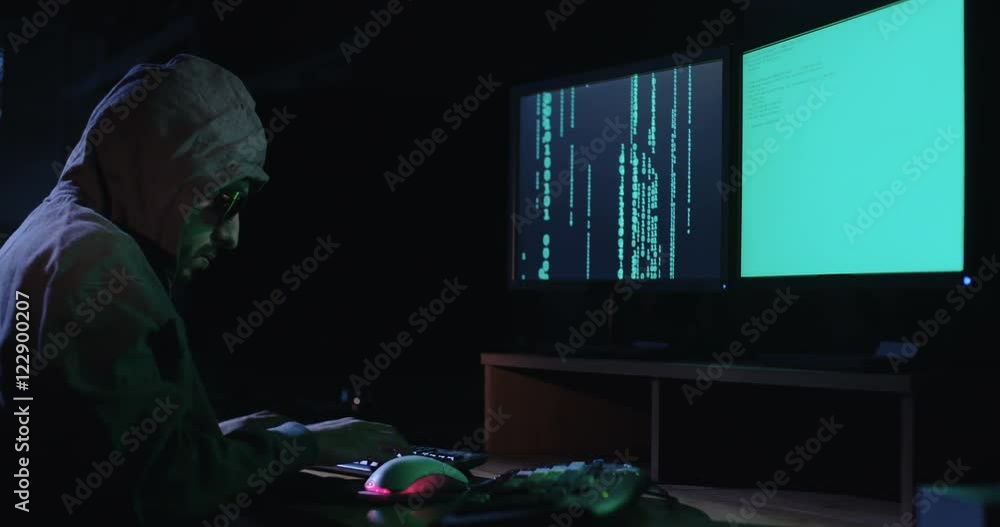 Cyber Terror - Computer Hacker sitting in a dark room in front of ...