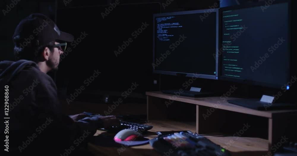 Cyber Terror - Computer Hacker sitting in a dark room in front of ...