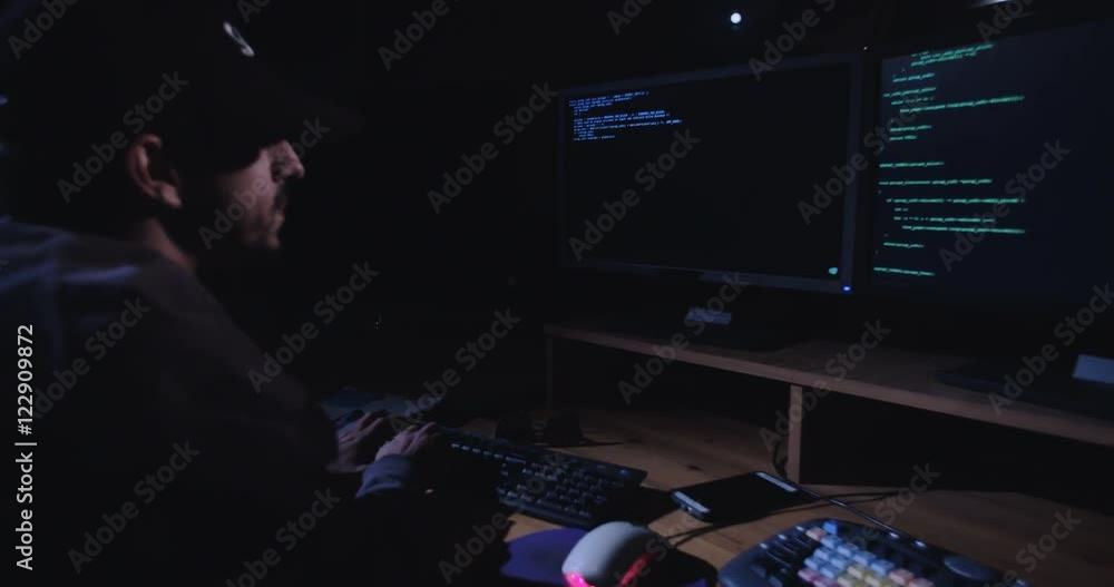 Cyber Terror - Computer Hacker sitting in a dark room in front of ...