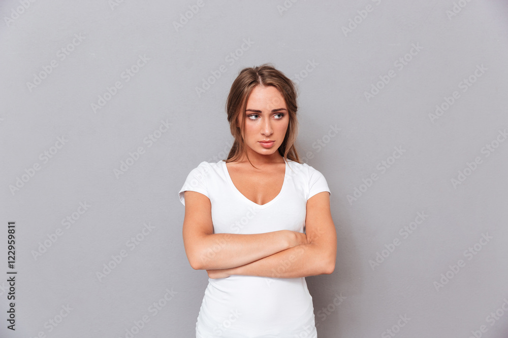 Sad upset young woman standing with arms crossed Stock Photo | Adobe Stock