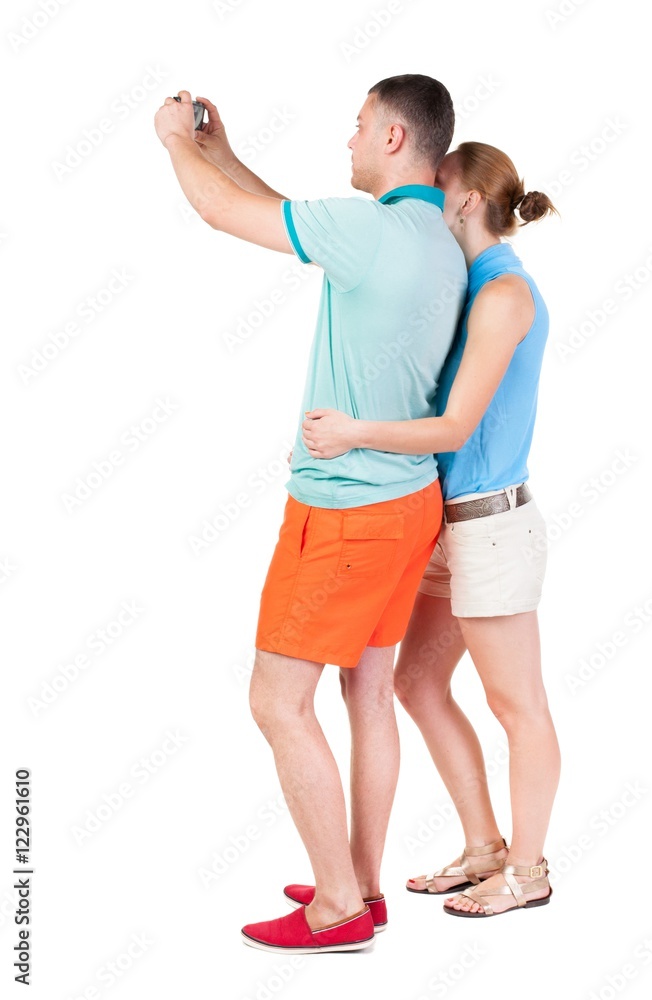 Back view of couple photographing. Tourists take pictures of the family ...