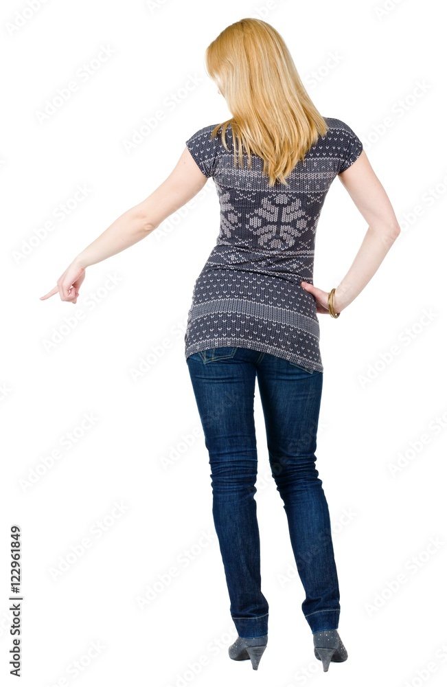 Back view of young brunette woman pointing at wall . beautiful girl in ...