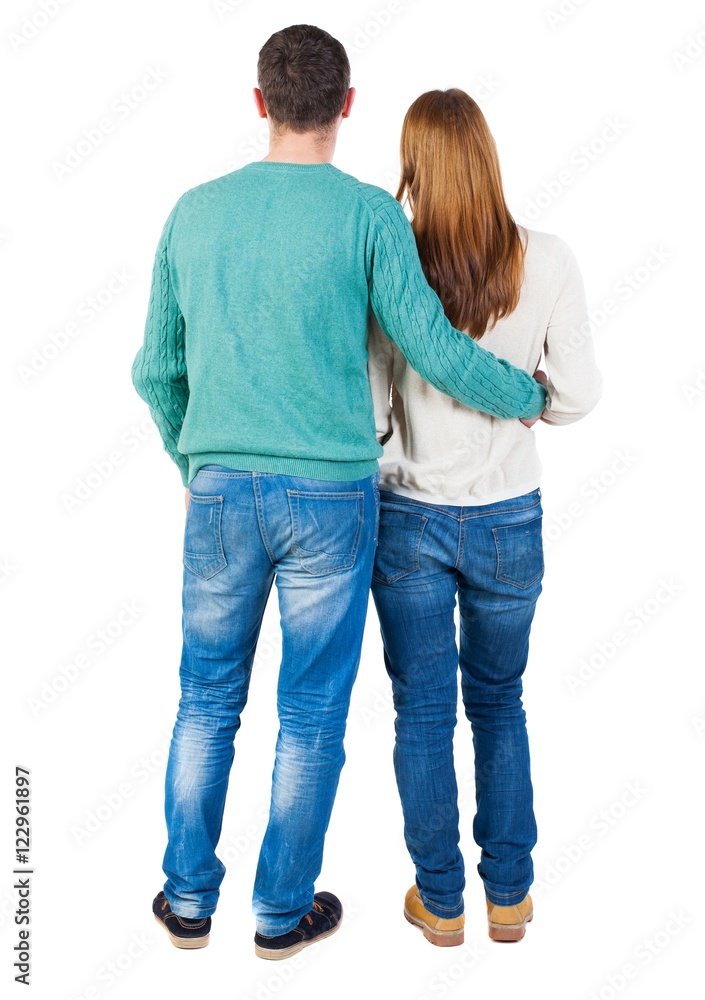 Back view of young embracing couple (man and woman) hug and look into ...