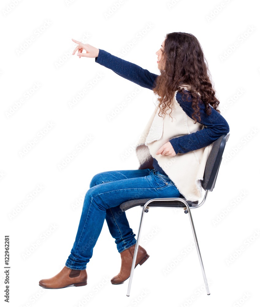 back view of young beautiful woman sitting on chair and pointing. girl ...