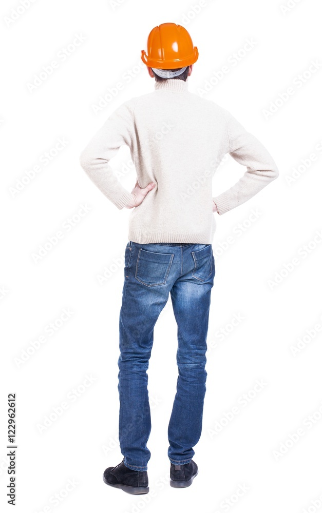 Backview of an engineer in construction helmet stands. Standing young ...