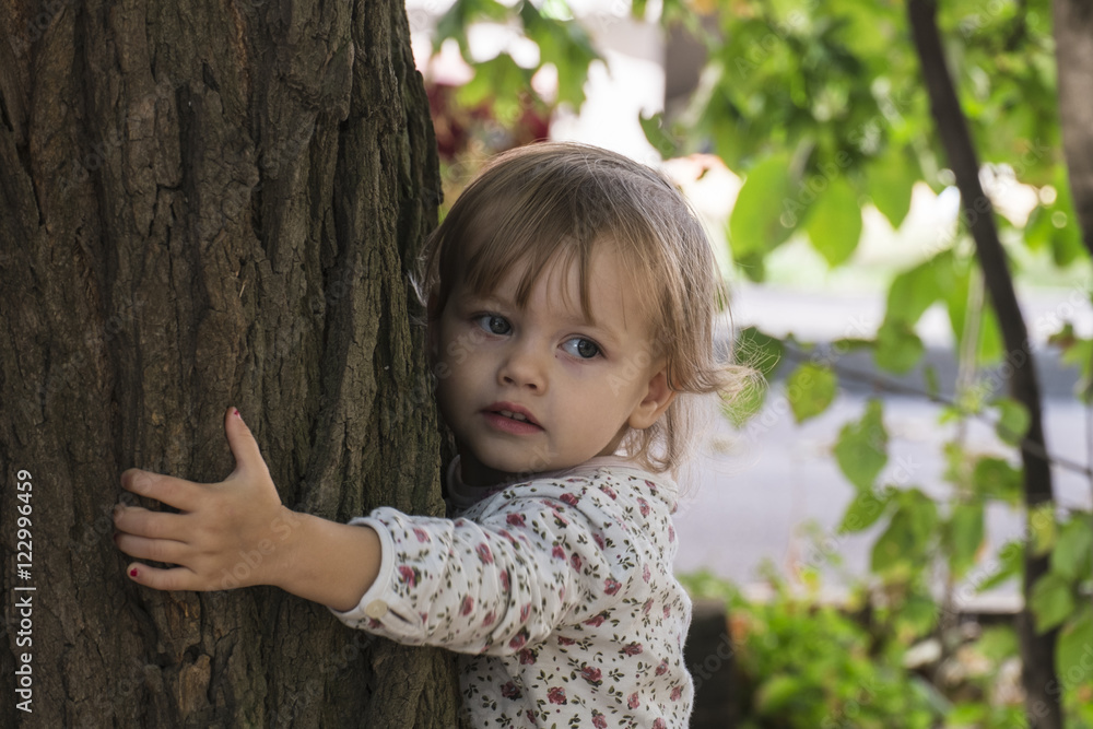Little girl hugging tree / Little girl is typed energy from of the tree ...