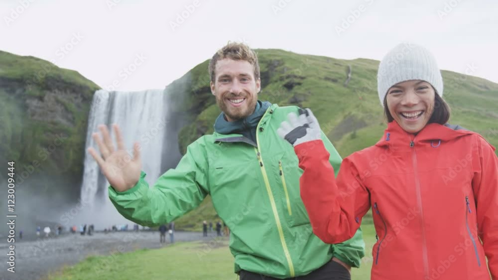 People waving hello with hand by Skogafoss waterfall on Iceland Ring ...