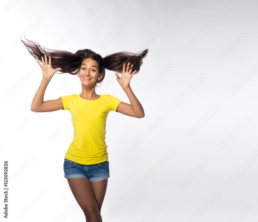 Emotional young brunette girl with long hair in yellow shirt on a white ...