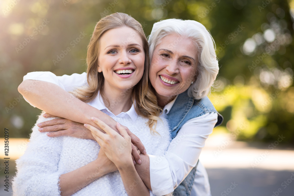 Two smiling friendly woman hugging in the park. Stock Photo | Adobe Stock