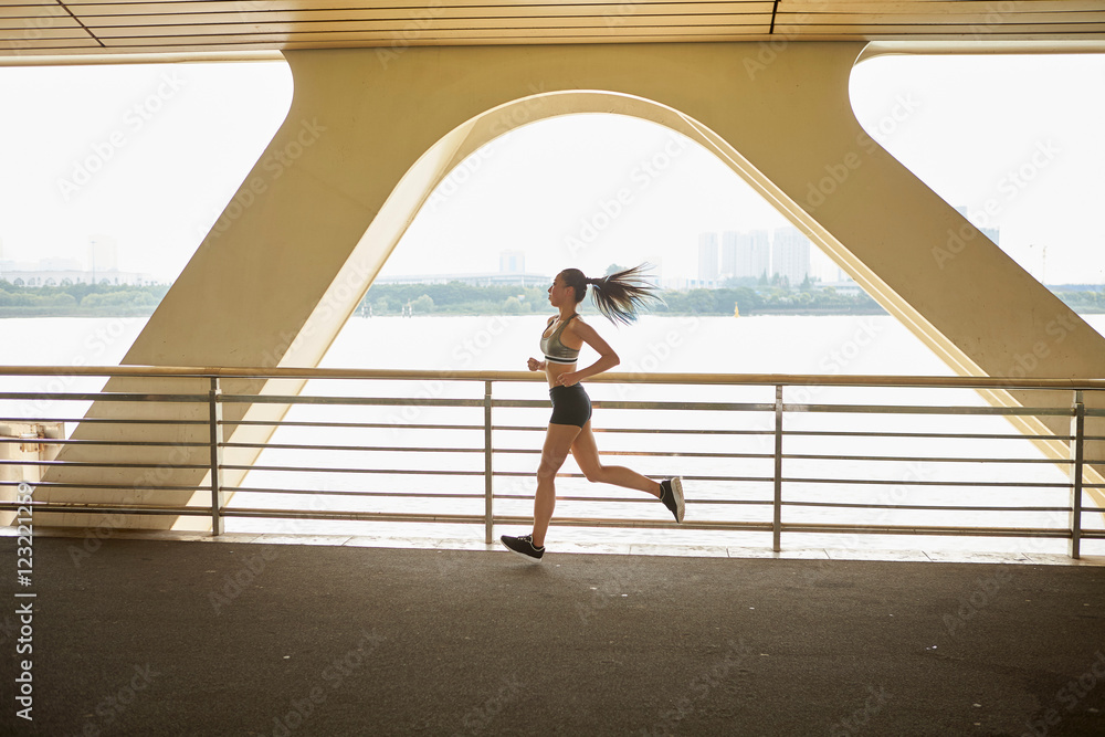 Woman jogging on elevated walkway, South Bund, Shanghai, China Stock ...