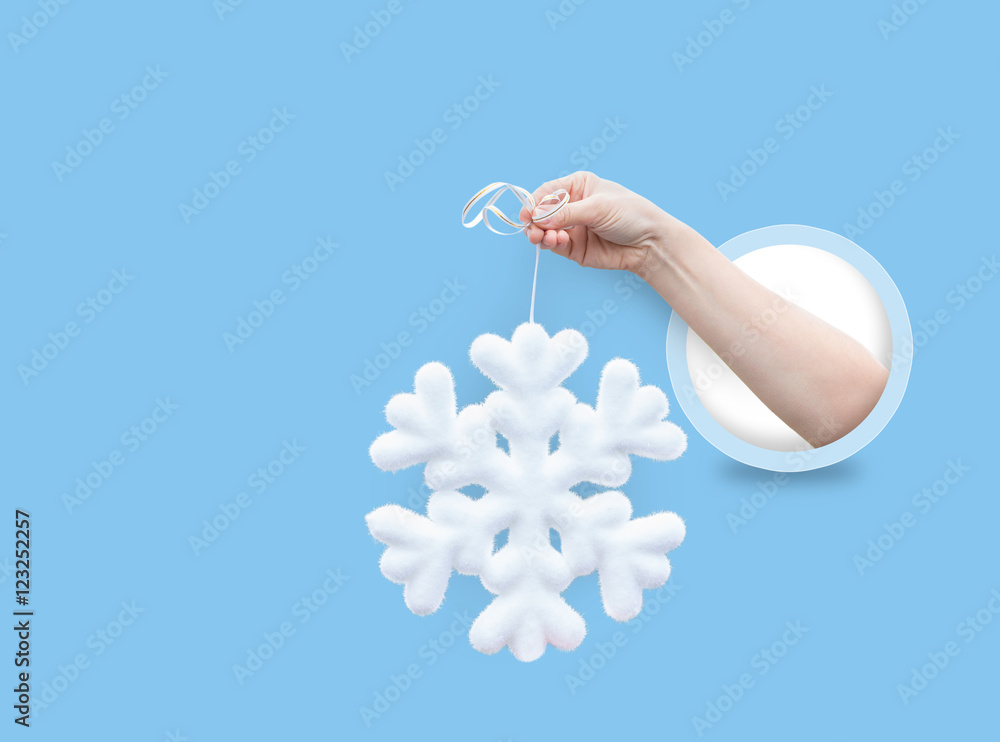Hand with snowflake on blue background Stock-Foto | Adobe Stock
