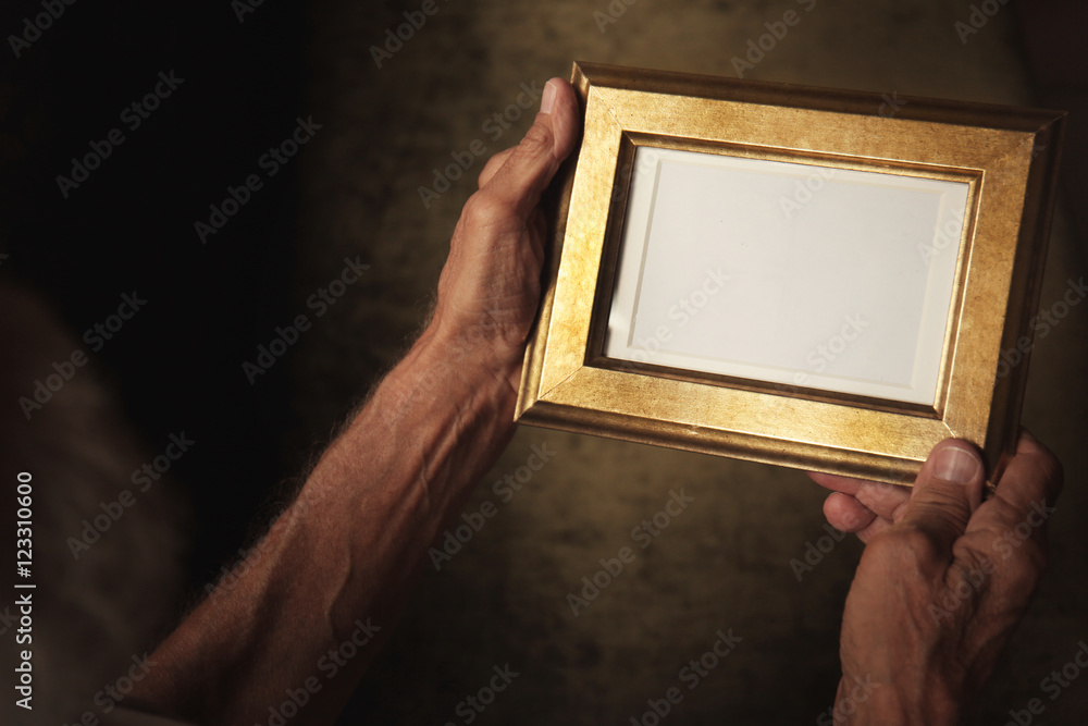 Old man holding and looking at photo frame Stock Photo | Adobe Stock