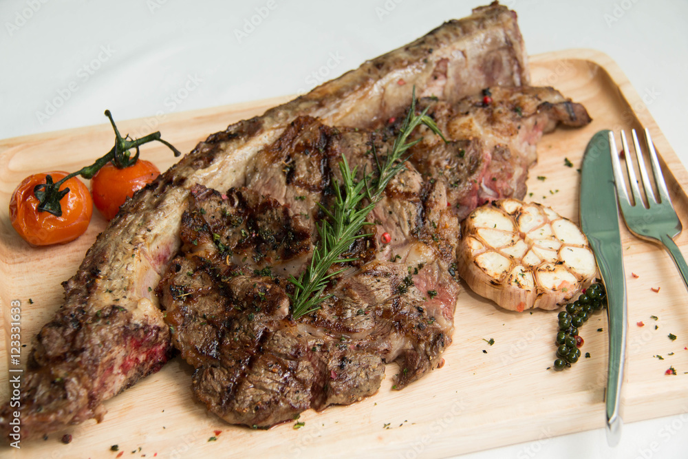 grilled tomahawk beef steak cut with fresh rosemary and tomat Stock ...