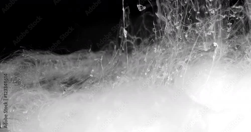 White Ink Filmed On Black Background. Wispy strands of white ink react ...