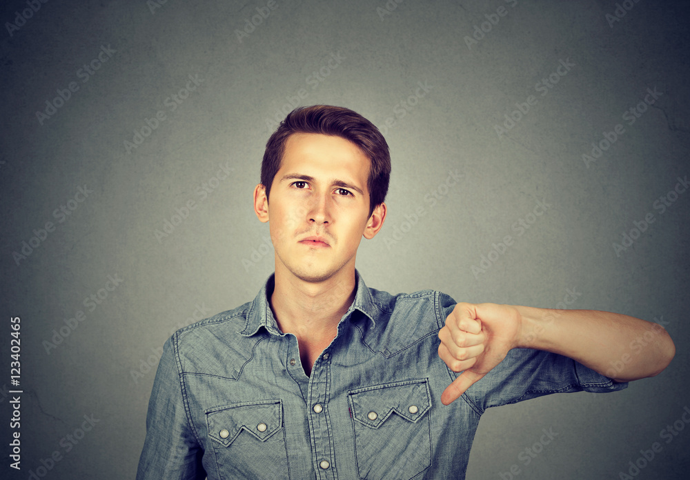 angry young man showing thumbs down sign, in disapproval Stock Photo ...