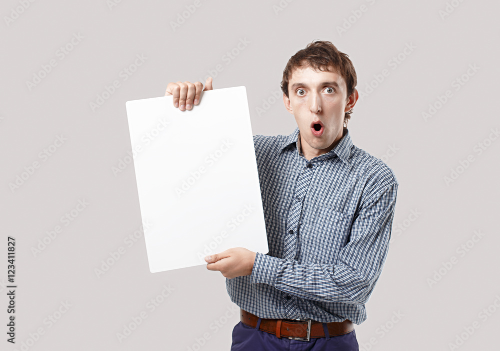 shocked man with a sheet of white paper in hands. guy opened his mouth ...