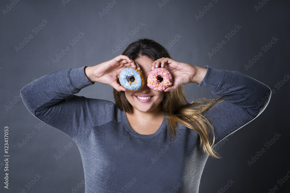 Happy beautiful young caucasian plus size model posing with donuts on a ...