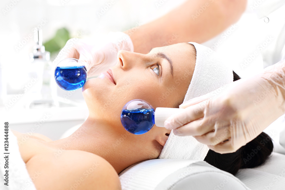 Masaż twarzy szklanymi kulami.Kosmetyczka wykonuje masaż twarzy. Stock ...