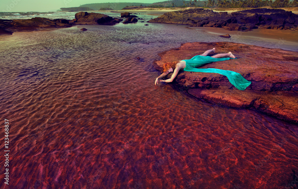 Woman lying in shallow sea wearing turquoise dress Stock Photo | Adobe ...